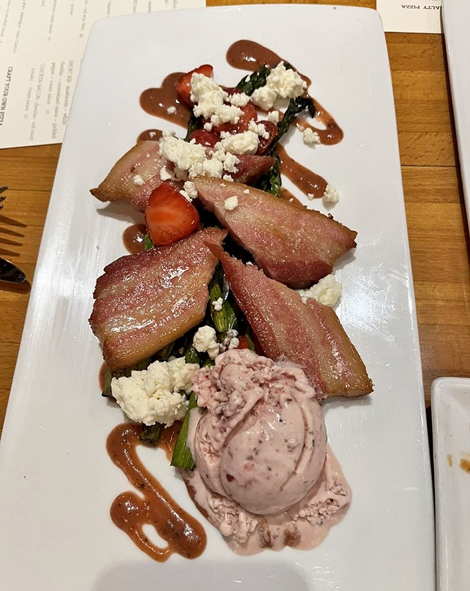 Perfectly seared pork belly rests on seasonal accompaniments, with strawberry and feta providing bright counterpoints to the rich meat.