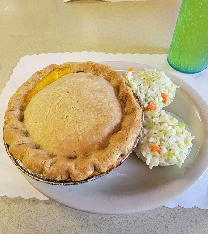 The Turkey Pot Pie arrives like edible architecture &ndash; a golden dome hiding savory treasures beneath, flanked by creamy coleslaw sentinels.