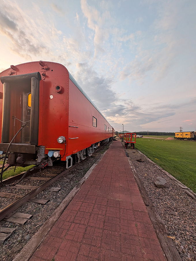 The crimson passenger car stands ready for boarding, its classic silhouette a reminder of when travel was an event, not just transportation.