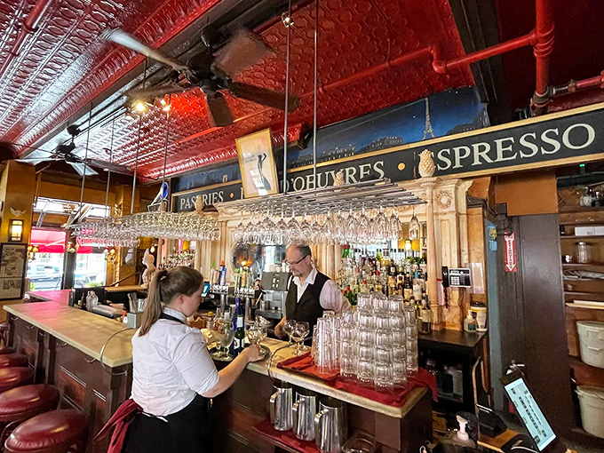 Behind the ornate bar, skilled hands craft cocktails and pour wines while the mirror reflects a room full of people making excellent life choices.