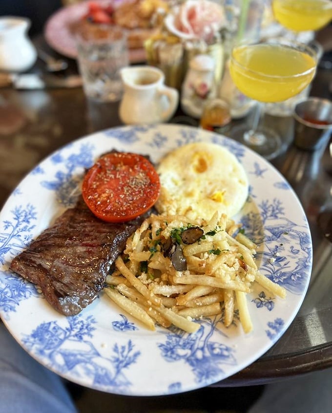 Steak and eggs living their best life on fine china. That perfectly cooked beef and those truffle fries are having a more sophisticated morning than most humans.