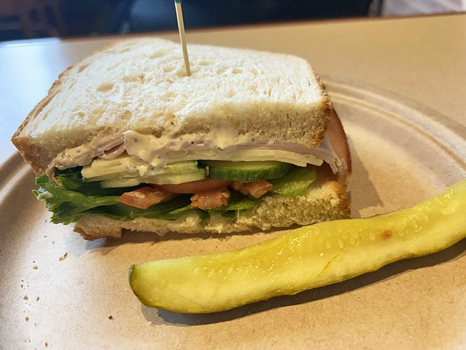 A perfectly crafted turkey sandwich with crisp vegetables and a pickle spear that somehow makes all other pickles seem like distant, inferior relatives.