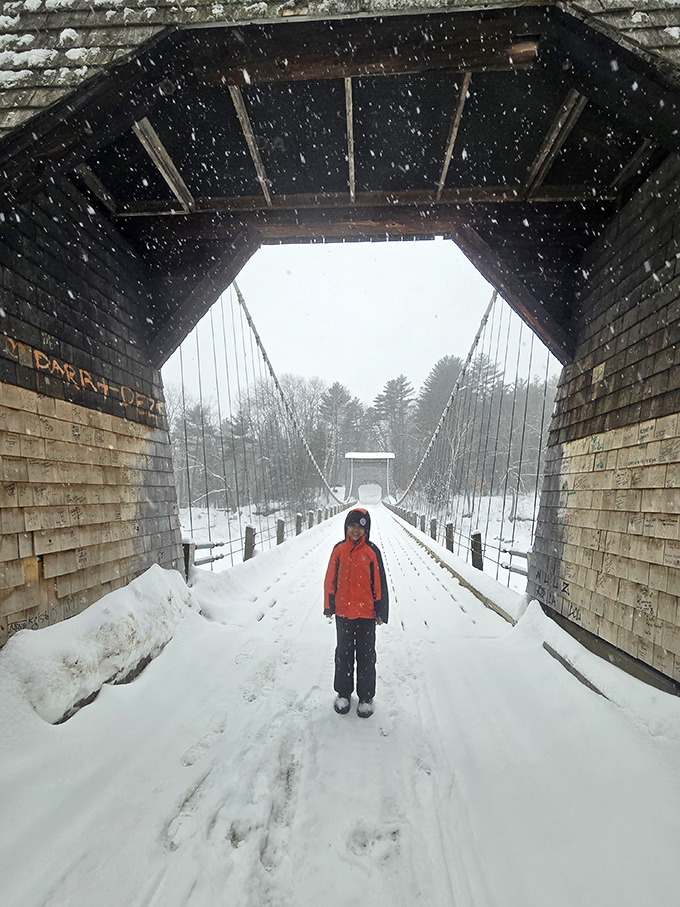 Snowflakes dance through the covered entryway, transforming this historic crossing into a winter wonderland tunnel.