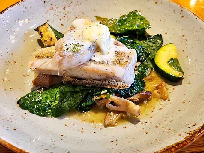Great Lakes walleye arrives with crispy skin and flaky flesh atop seasonal vegetables, reminding diners that Michigan's freshwater bounty rivals any ocean offering.