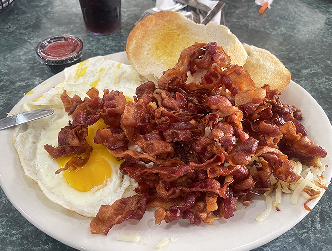 Breakfast nirvana achieved: eggs sunny-side up swimming in a sea of crispy bacon that's measured by the pound, not the strip.