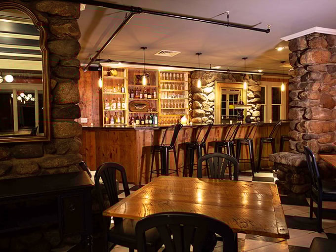 The inn's bar area features rustic stone walls and warm wooden accents &ndash; perfect for sampling local Vermont spirits.