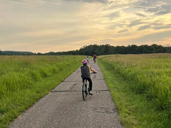 Young cyclists pedal through golden prairie grasses at sunset, the wide-open trail perfect for riders of all ages.
