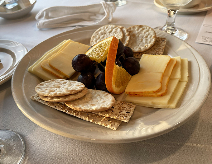 The appetizer cheese plate offers a savory start to the evening's culinary journey, with various textures and flavors to awaken the palate.