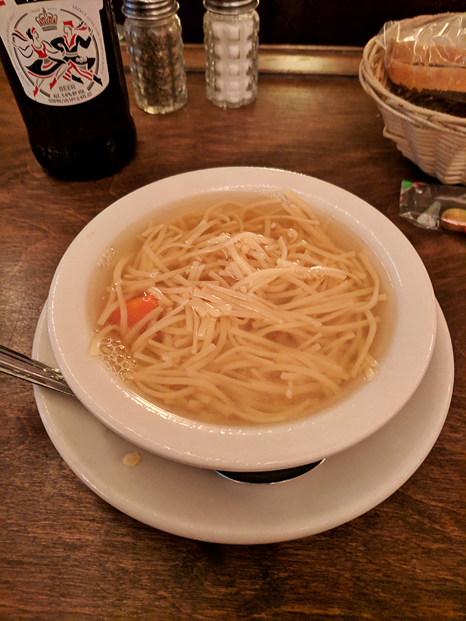 A bowl of chicken noodle soup that puts all other chicken soups to shame, with thin noodles swimming in broth that's clearly been simmering for hours.