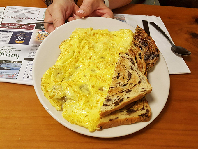 Fluffy scrambled eggs alongside marbled rye toast &ndash; simple breakfast perfection that reminds you why diners endure.
