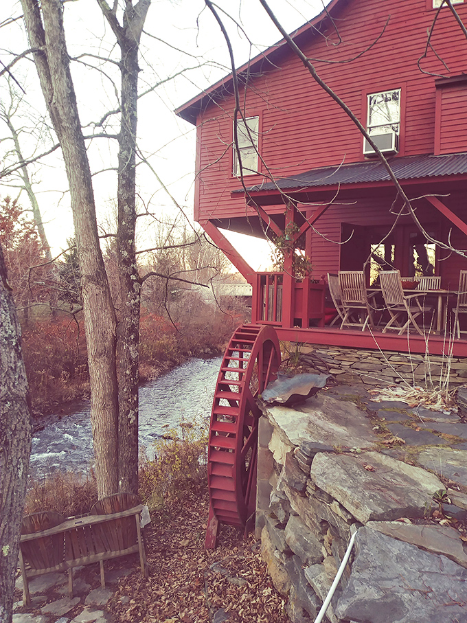 That red waterwheel isn't just for show, it's working history, churning alongside the river that's been Woodstock's lifeblood for centuries.