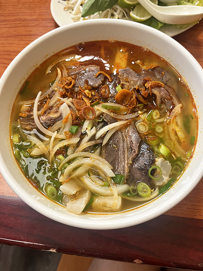 A steaming bowl of spicy pho showcases tender beef slices, aromatic broth, and fresh herbs &ndash; Vietnam in a bowl.