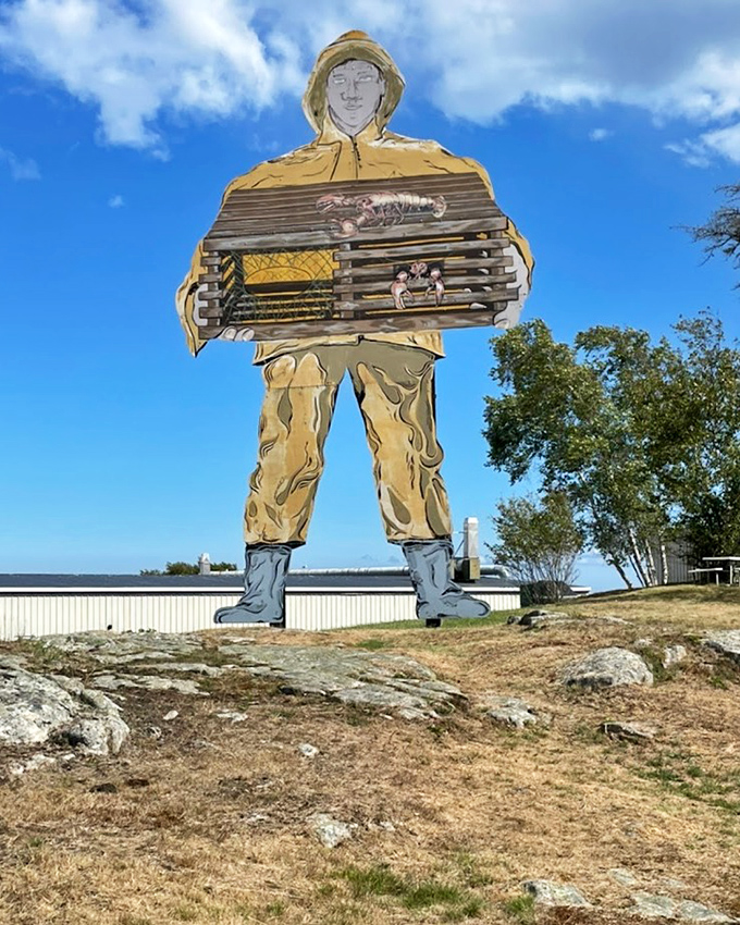 Big Jim the Fisherman stands tall against the Maine sky, a wooden tribute to the state's lobstering heritage and the people who make their living from the sea.