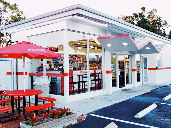 Fray's bright white building with red accents and Coca-Cola umbrellas creates the perfect classic American donut shop atmosphere.