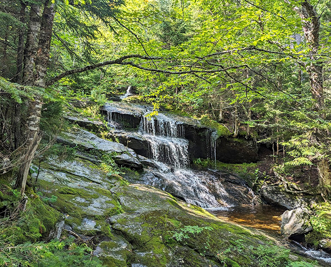 Hidden in Grafton Notch's emerald forest, this delicate waterfall drapes over moss-covered stone like a liquid curtain, whispering secrets to those who listen.
