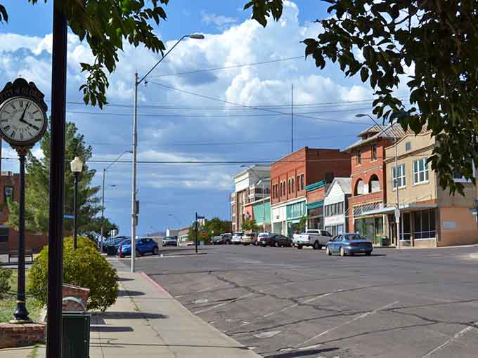 Wide main street stretches through historic downtown where mountain backdrop meets authentic small-town Arizona living.