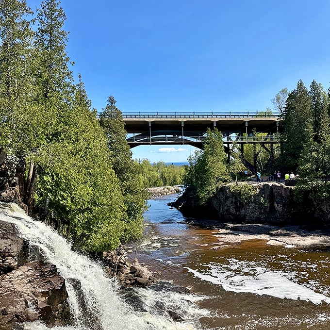 Gooseberry Falls tumbles over ancient rock formations beneath a highway bridge, offering roadtrippers a spectacular natural show just steps from their car.