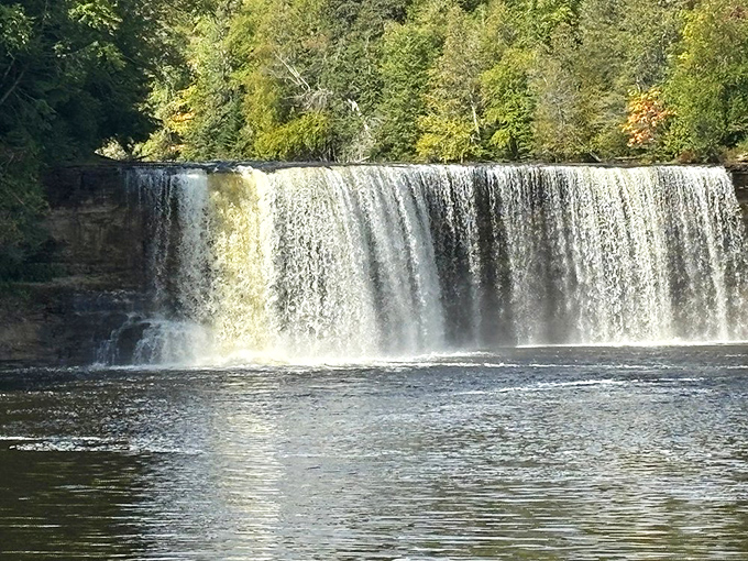 The powerful Upper Tahquamenon Falls demonstrates Mother Nature's raw power, especially impressive against the lush green backdrop.
