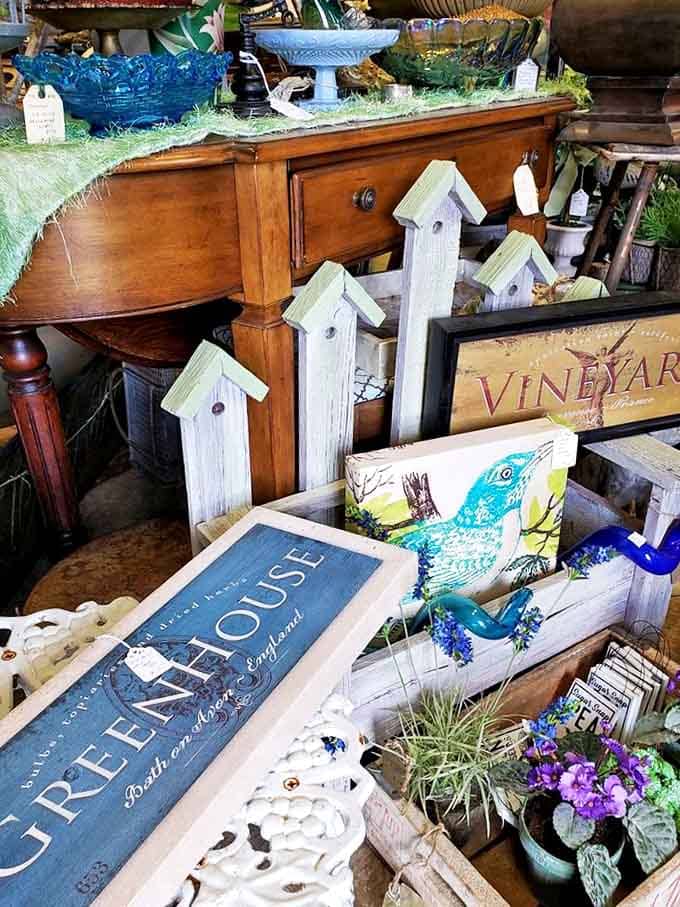 Whimsical birdhouses and vintage signs create a charming vignette that could transform any modern home with touches of nostalgia.