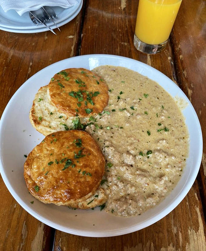 Biscuits and gravy that would make a Southern grandmother nod in approval – fluffy, buttery clouds swimming in savory gravy heaven.