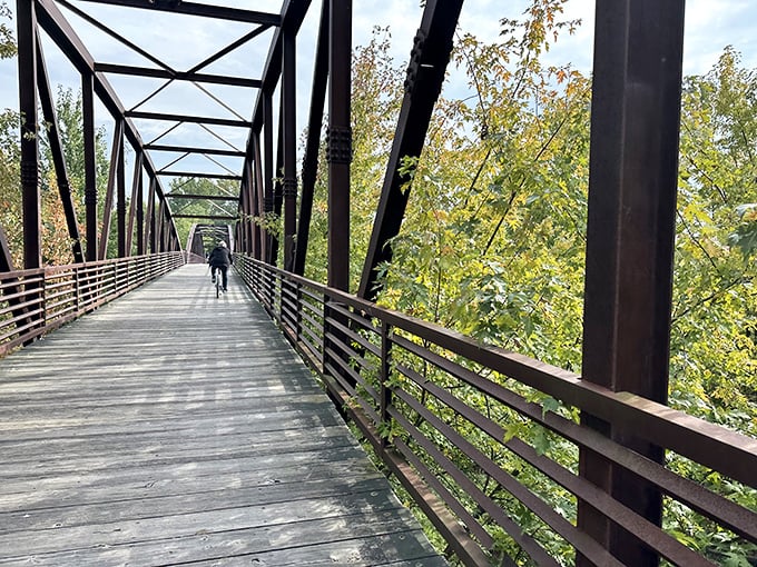 The historic railroad bridge adds industrial charm to natural beauty – engineering marvel meets Vermont splendor.