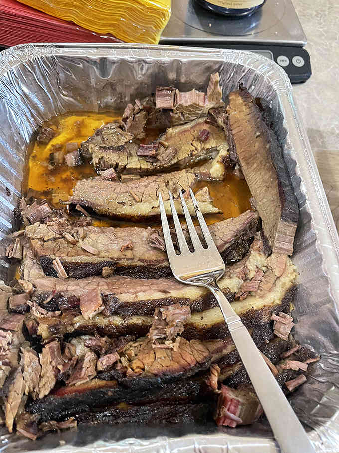 Brisket with a smoke ring so perfect it could be framed, sliced to showcase the juicy interior beneath a bark of concentrated flavor.