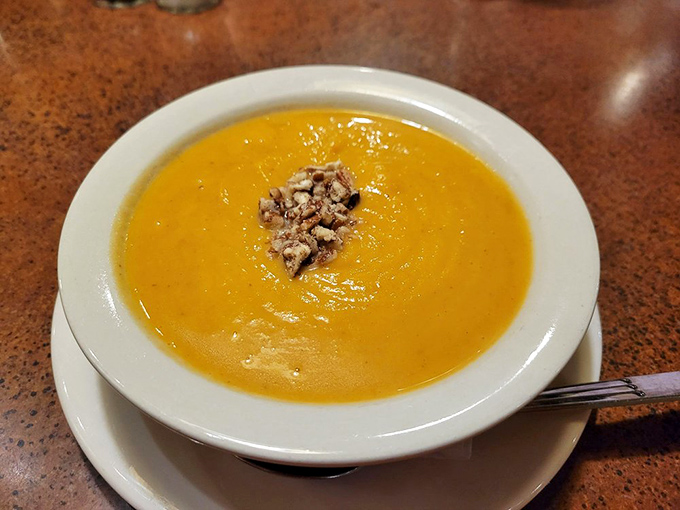 Velvety autumn in a bowl, topped with spiced nuts that add crunch and complexity to each spoonful of liquid gold.