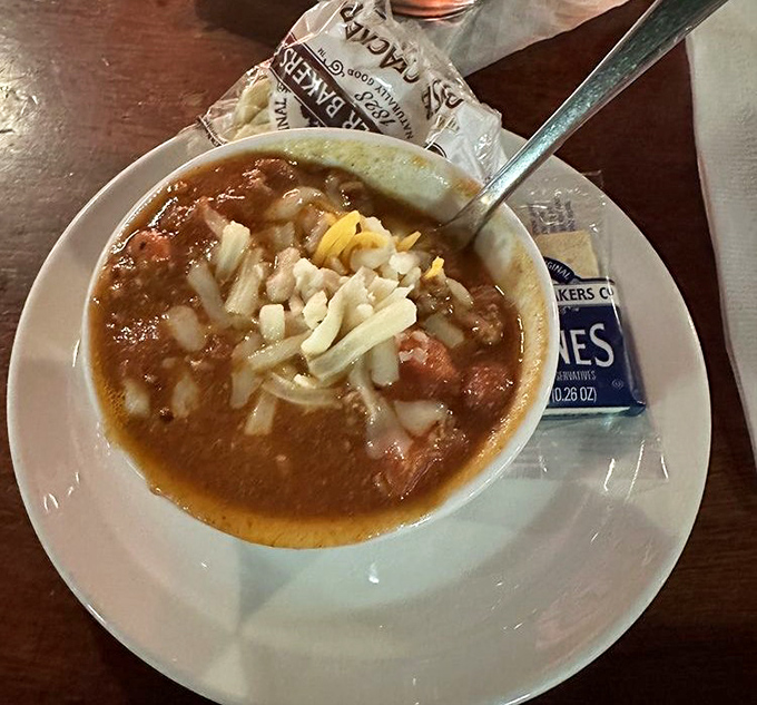 A bowl of soul-warming chili topped with diced onions and cheese, the kind that makes Michigan winters almost bearable.