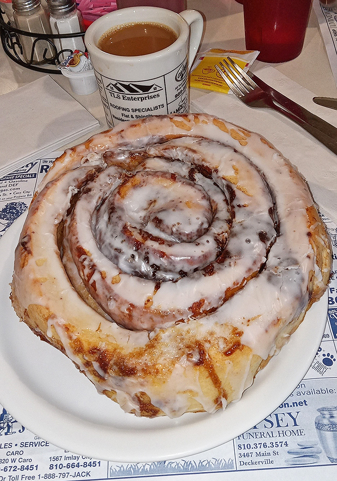 Morning perfection: A steaming cup of diner coffee stands guard beside a cinnamon roll that's practically begging to be photographed.