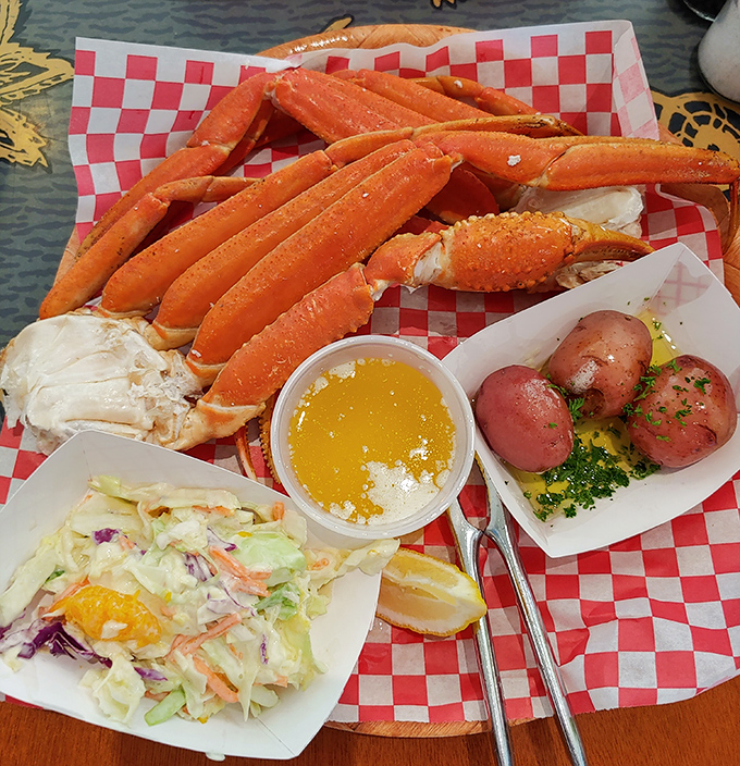 Snow crab legs sprawled across checkered paper &ndash; nature's puzzle that rewards persistent crackers with sweet, tender meat worth every effort.