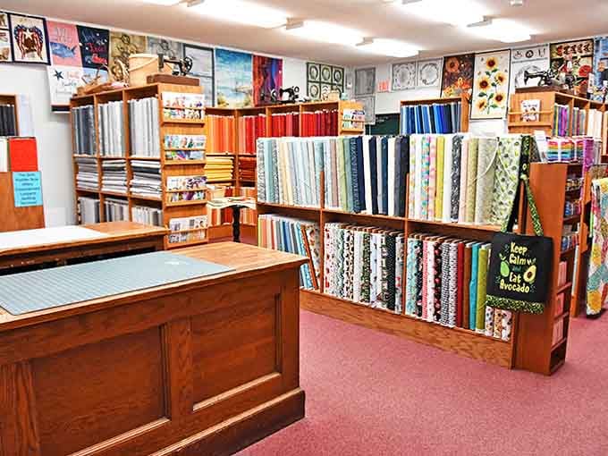 Fabric bolts stand at attention like colorful soldiers, each one whispering possibilities of future projects.