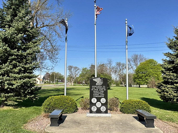 Veterans memorial standing proud with flags flying, honoring those who served from this small prairie community.