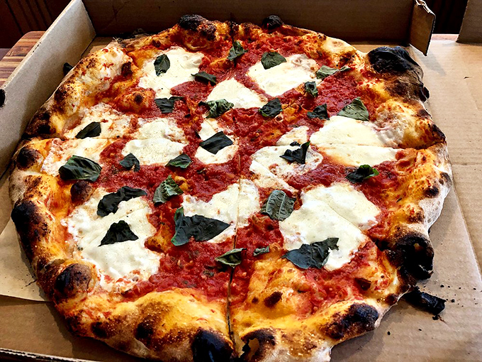 Margherita Pizza: Simplicity perfected – fresh basil leaves dance across pools of melted mozzarella, all atop a sauce that tastes like summer sunshine.