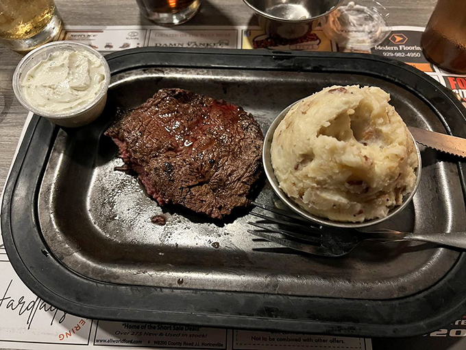 Steak and mashed potatoes executing the classic comfort food playbook perfectly, no notes, just pure satisfaction on a sizzling platter.