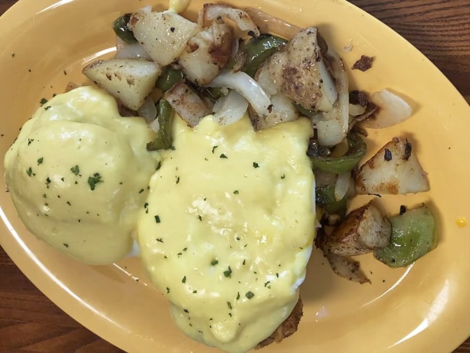 Eggs Benedict with hollandaise so velvety it should be illegal, alongside home fries seasoned by decades of griddle wisdom.