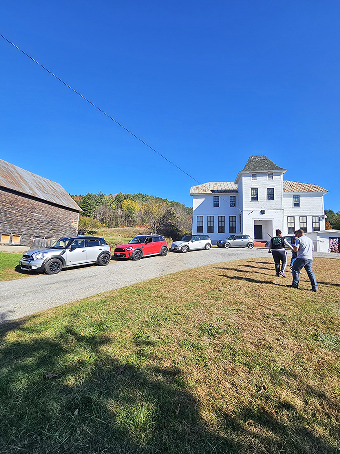 Car enthusiasts gather outside the historic building, sharing stories and admiring views in a scene that blends modern convenience with timeless charm.