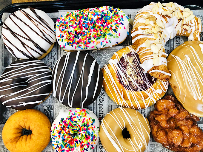 This donut lineup looks like a sugary fashion show, each one dressed to the nines in chocolate drizzle, rainbow sprinkles, or that classic glaze perfection.