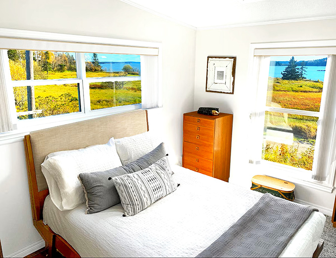 Wake up to waterfront wonder through these bedroom windows framing Maine's coastline like living paintings.