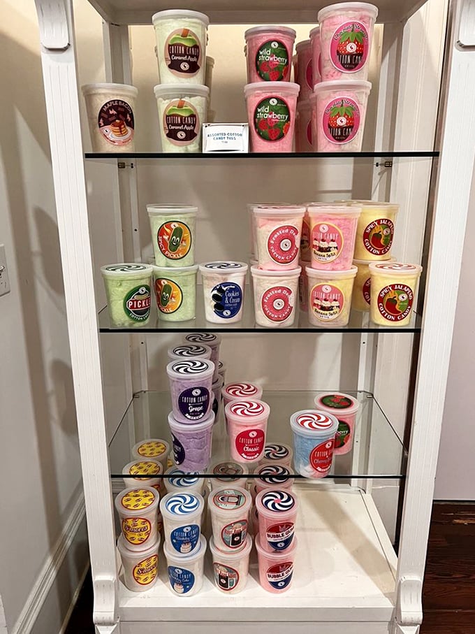 Cotton candy containers stacked like a laboratory of sweetness, each holding fluffy clouds of spun sugar in flavors beyond imagination.