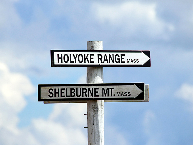 Directional signposts pointing to neighboring states, as if Vermont is generously sharing its mountain views with Massachusetts.