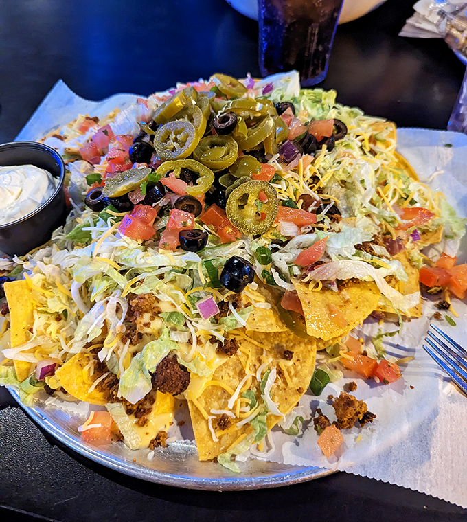 This mountain of nachos requires strategy and stamina. Veterans start at the edges and work inward, savoring each perfectly loaded chip.