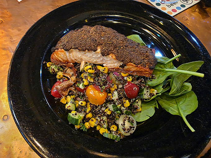 The peppercorn-crusted swordfish rests atop a vibrant corn and tomato salad &ndash; a study in contrasts between the rich fish and the fresh summer vegetables.