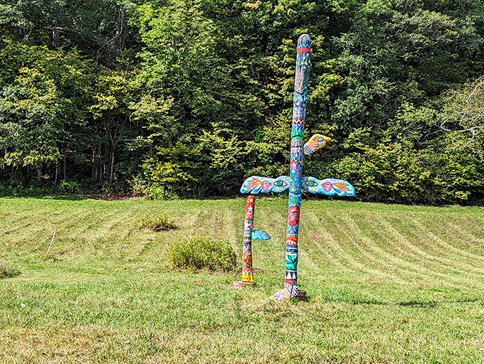 This whimsical totem pole brings a splash of color to the meadow, its playful designs reaching skyward like a prayer to creativity.