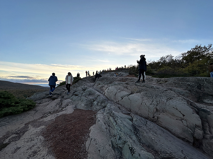 Visitors gather along the rocky overlook, each finding their own perfect spot to absorb the panoramic views.