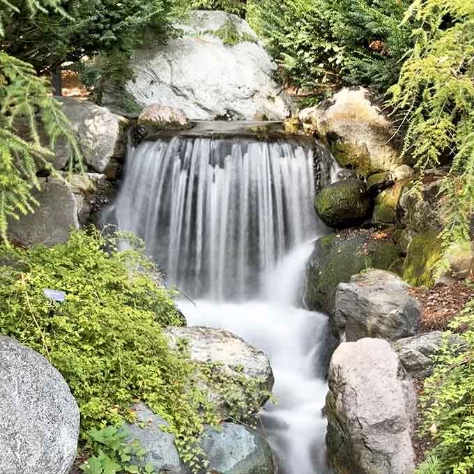 Water cascades over ancient stones in this tranquil waterfall, nature's own meditation soundtrack playing on endless repeat.