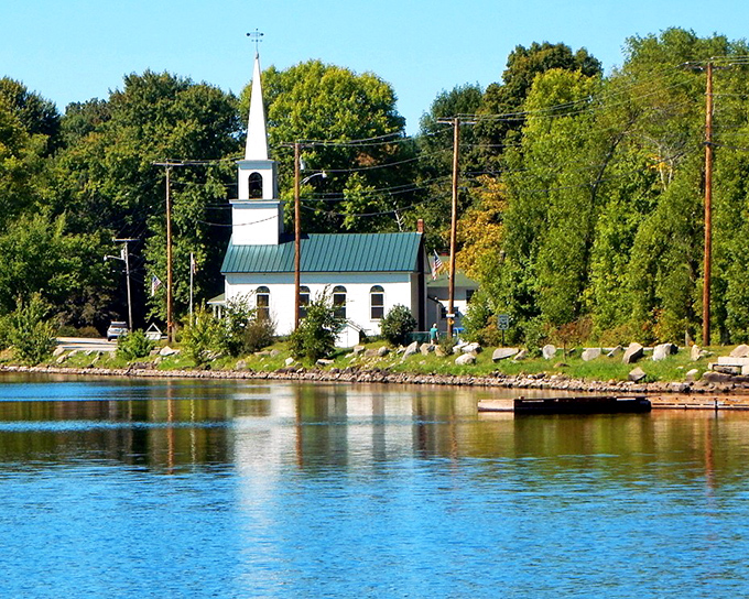 The white church steeple in China creates a classic New England scene against the backdrop of Maine's beautiful natural landscape.