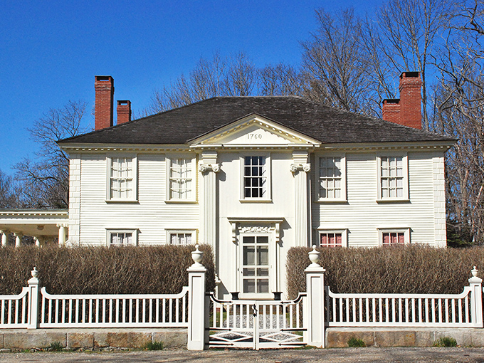 This elegant white colonial home in Kittery represents the town's maritime heritage, complete with traditional white picket fence and formal landscaping.