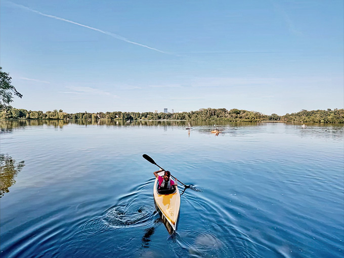 A lone kayaker glides across mirror-smooth water, finding the kind of peace and quiet that makes Minnesota's lakes true treasures.
