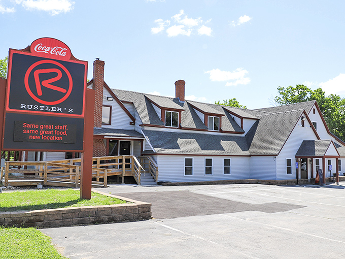 Rustler's Steakhouse's bold red sign stands out against its white farmhouse-style building. The Coca-Cola logo adds a classic touch to this Windham favorite.