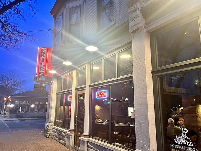 Skiles Tavern's vintage neon sign glows invitingly against the evening sky, a beacon for Holland's pizza lovers seeking thin-crust perfection.